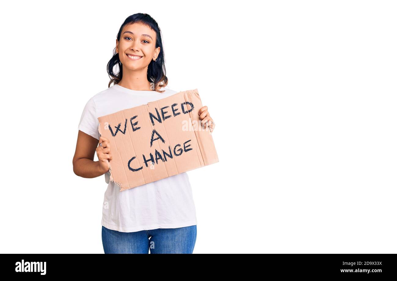 Young woman holding we need a change banner looking positive and happy ...