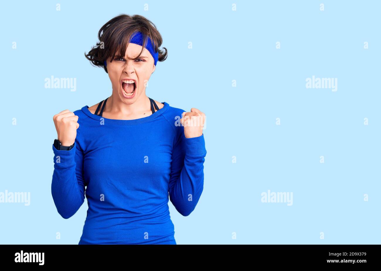 Beautiful young woman with short hair wearing training workout clothes ...