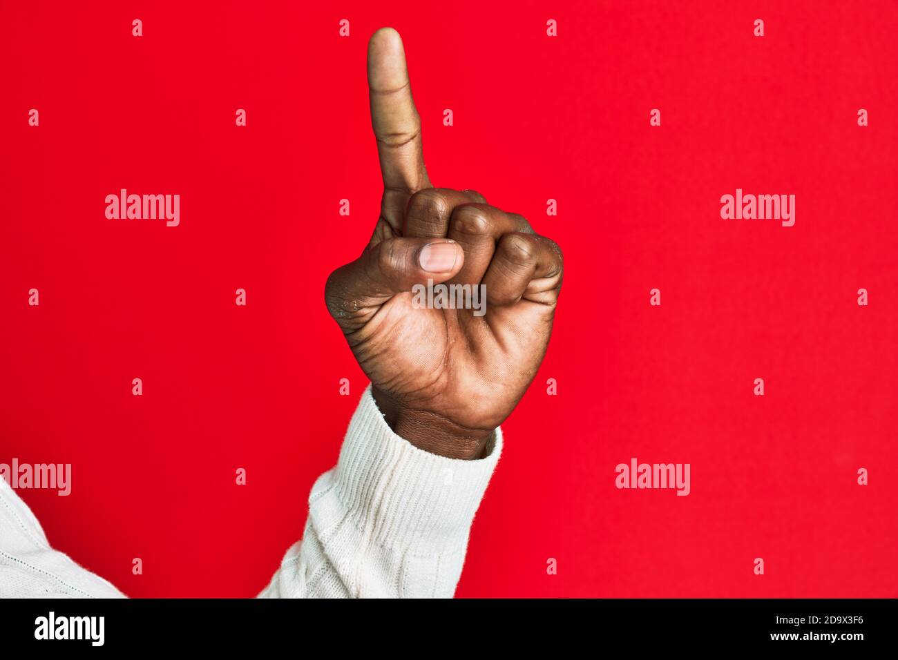 Arm and hand of african american black young man over red isolated ...