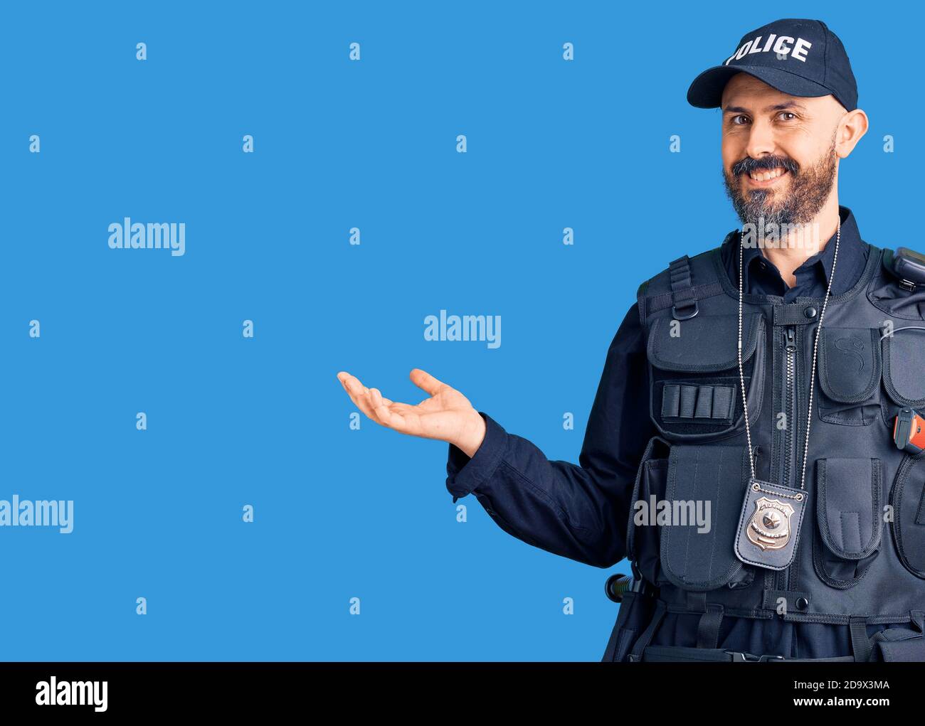 Young handsome man wearing police uniform smiling showing both hands ...