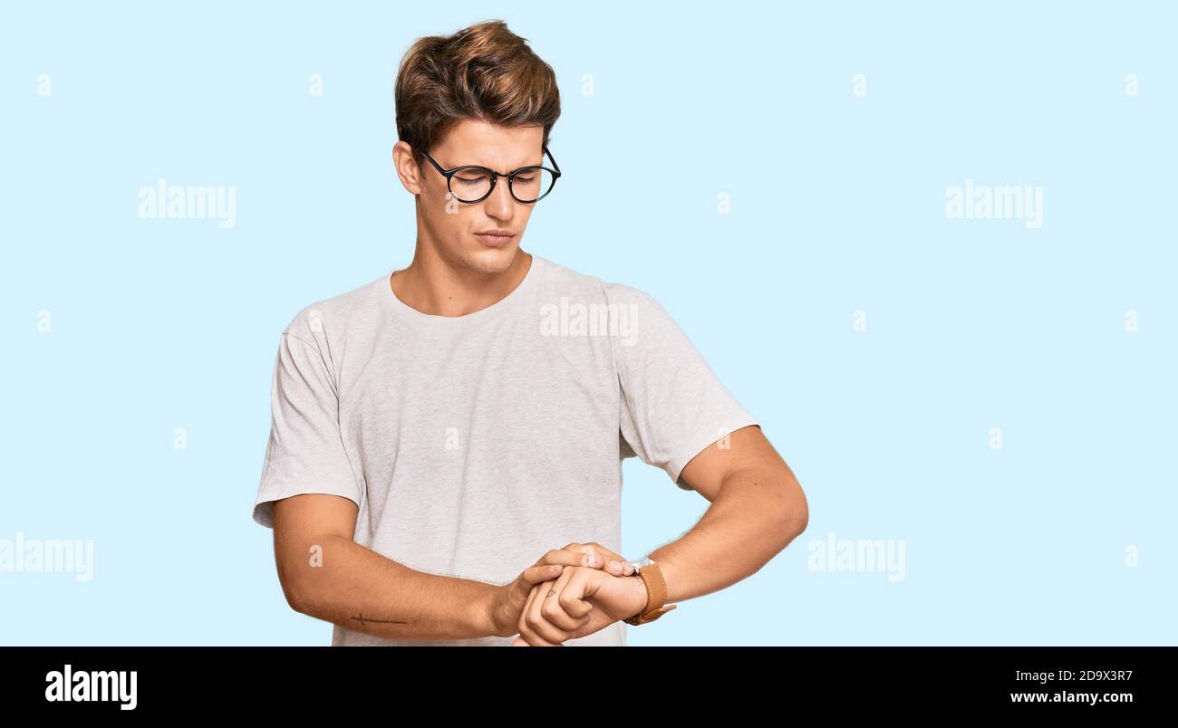 Handsome caucasian man wearing casual clothes and glasses checking the ...