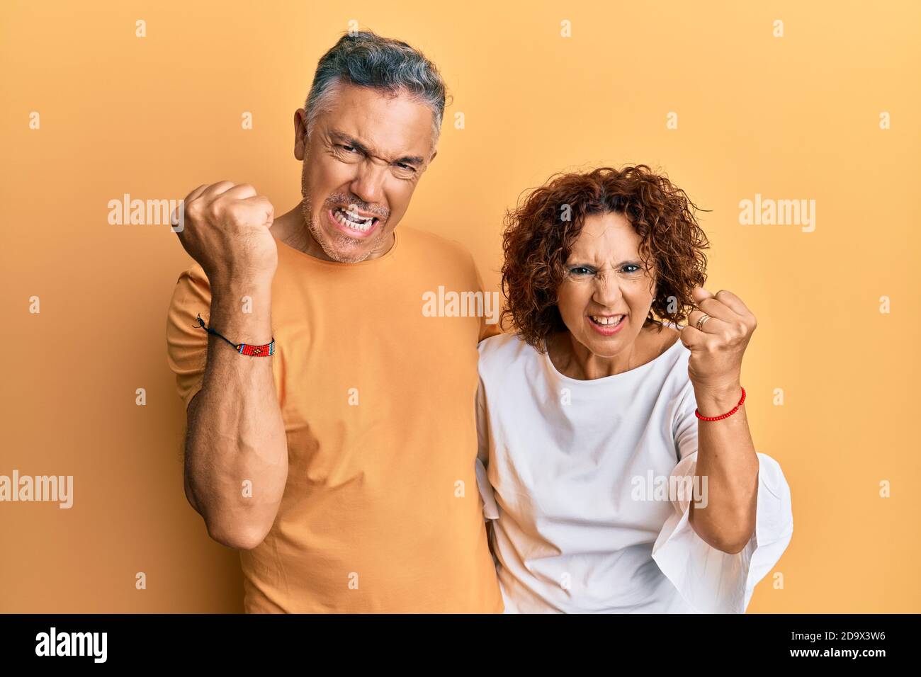 Beautiful middle age couple together wearing casual clothes angry and ...
