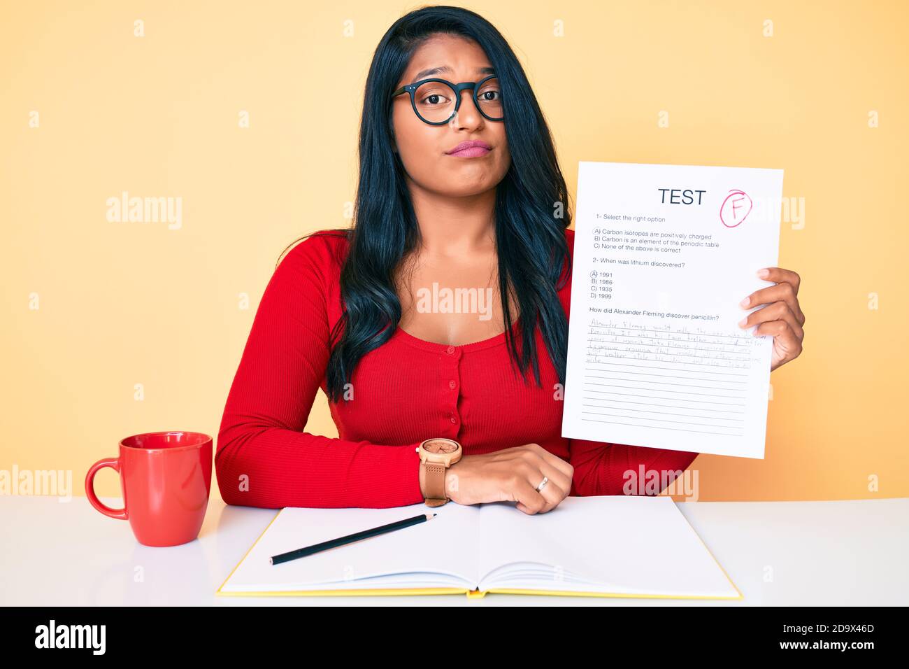 Beautiful latin young woman with long hair showing a failed exam ...