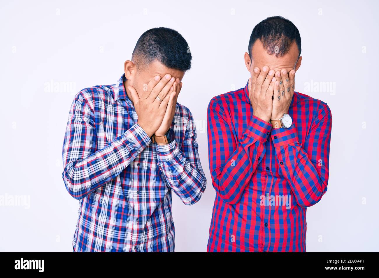 Young gay couple of two men wearing casual clothes with sad expression ...