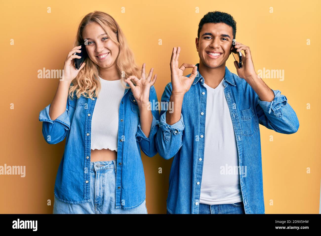 Young interracial couple having conversation talking on the smartphone ...