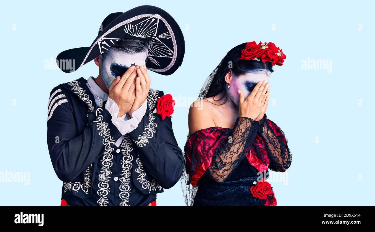 Young couple wearing mexican day of the dead costume over background ...