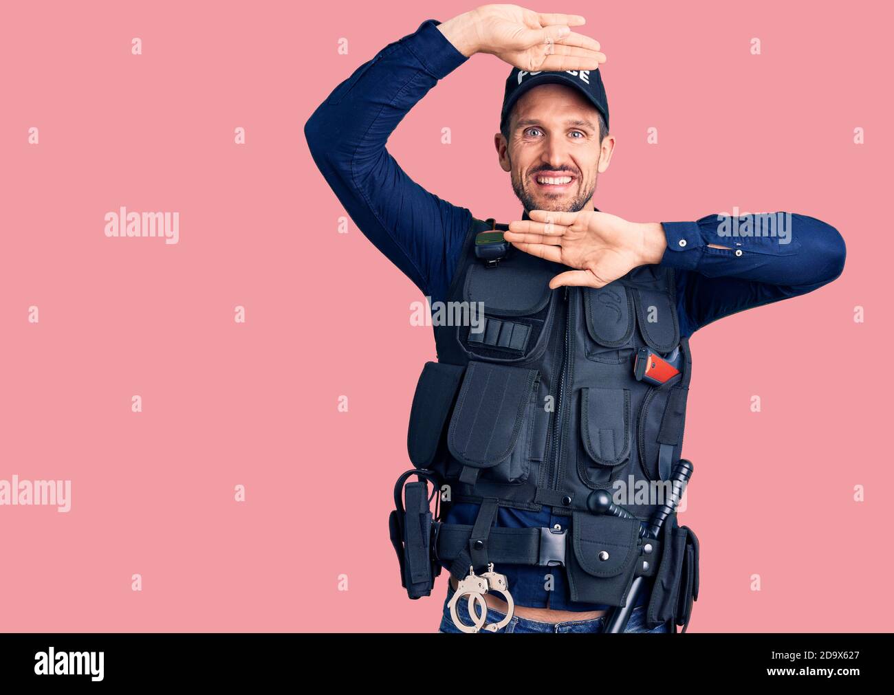 Young handsome man wearing police uniform smiling cheerful playing peek ...