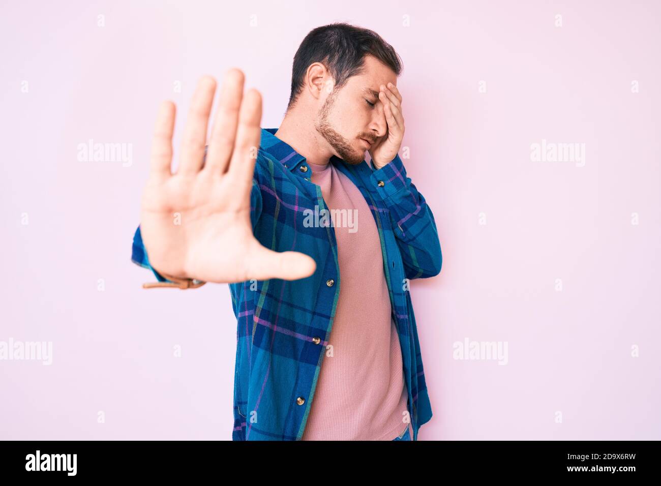 Young handsome man wearing casual clothes covering eyes with hands and ...