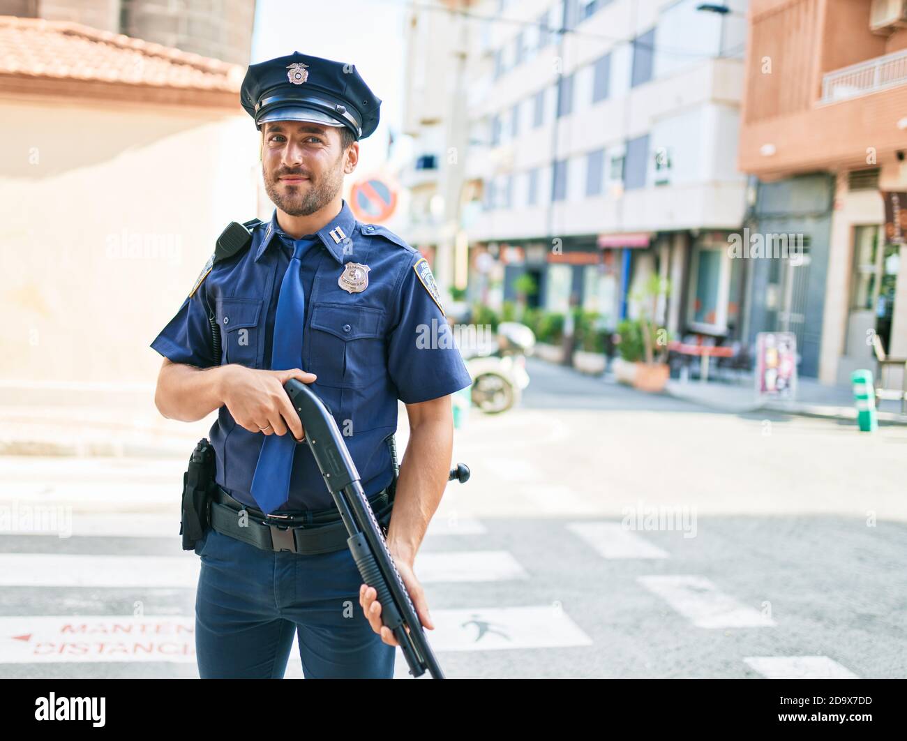 Young handsome hispanic policeman wearing police uniform smiling happy ...