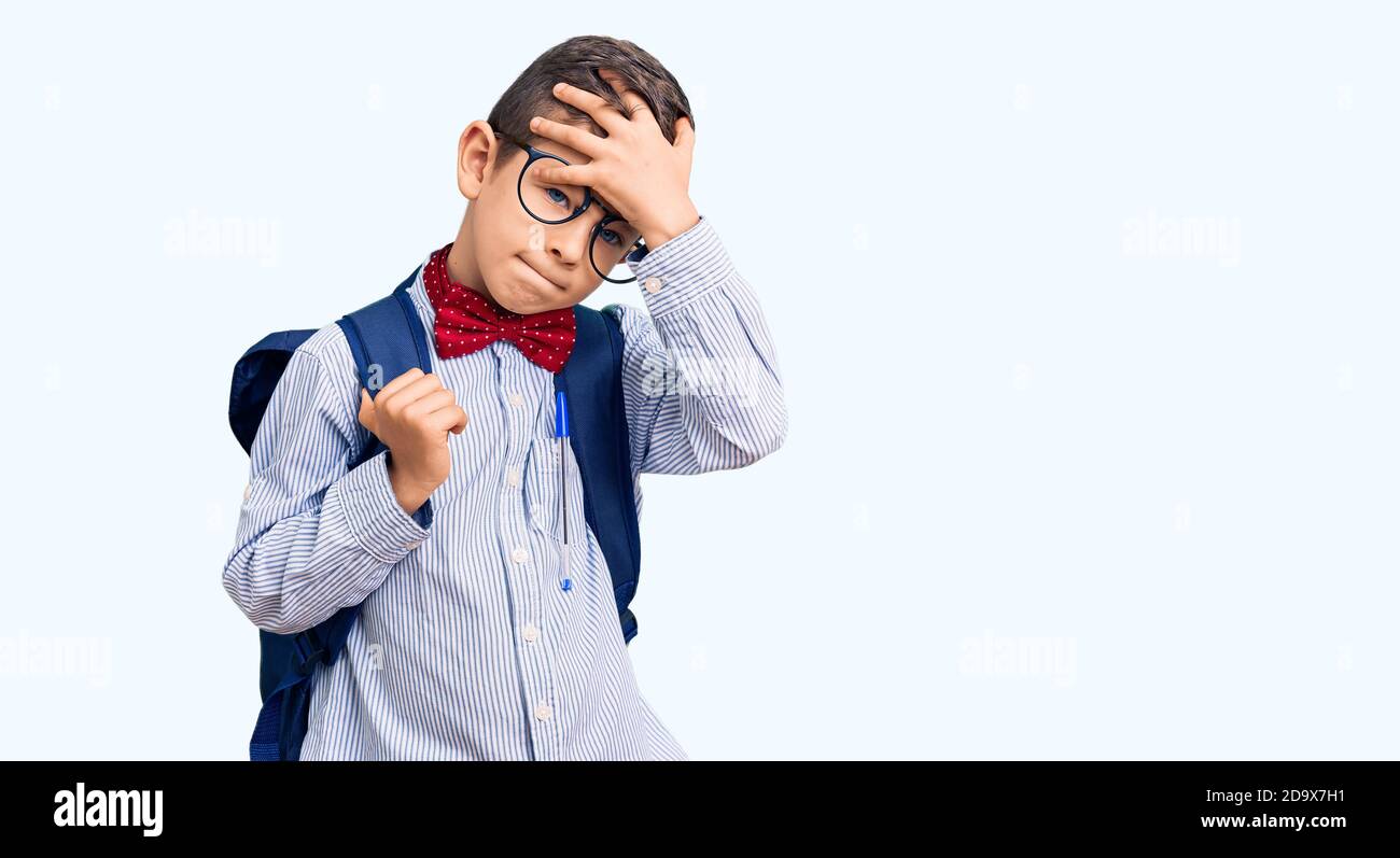 Cute blond kid wearing nerd bow tie and backpack stressed and ...