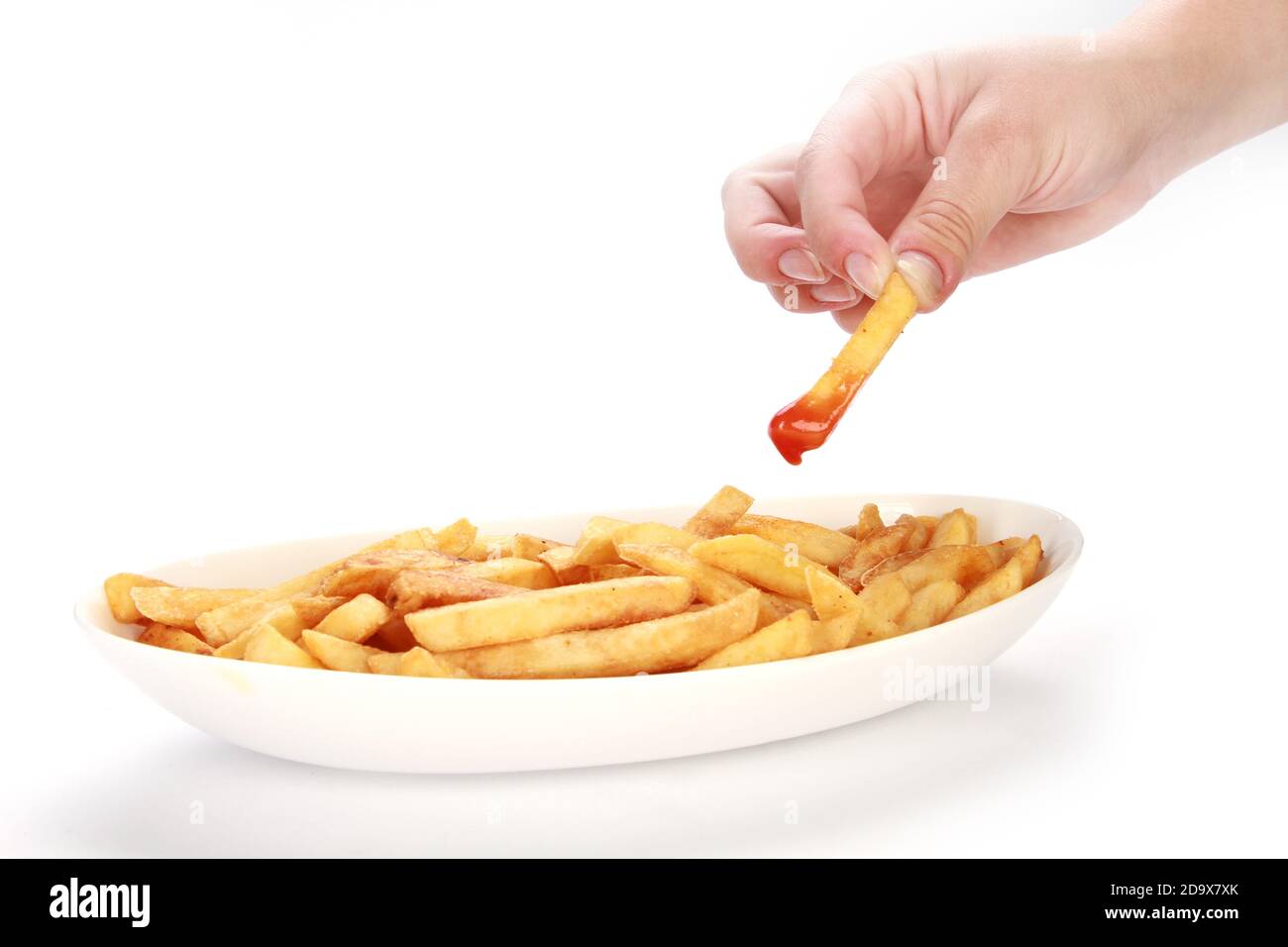 Man's hand picking a piece of french fries with catsup isolated on ...