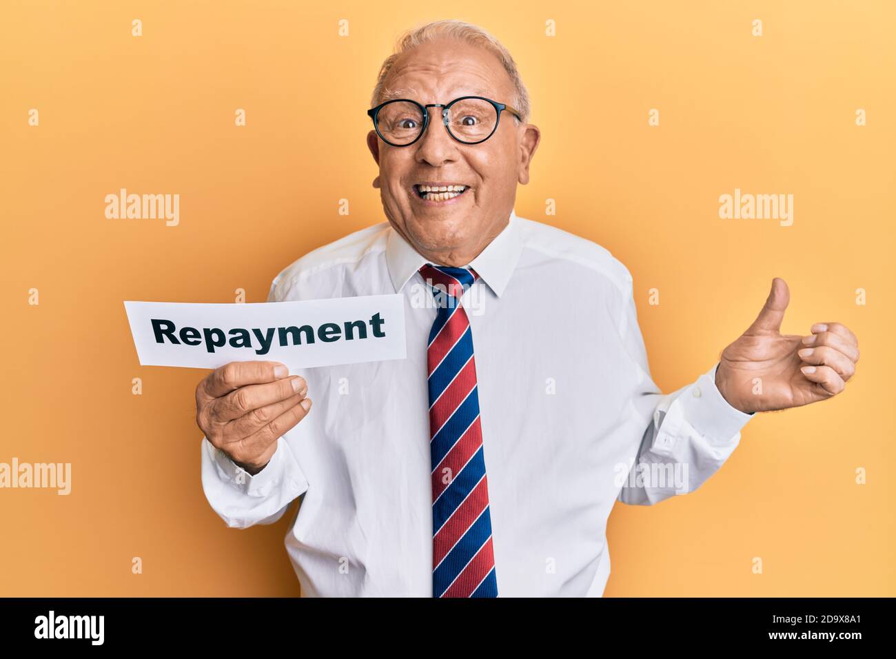 Senior caucasian man holding repayment word paper screaming proud ...