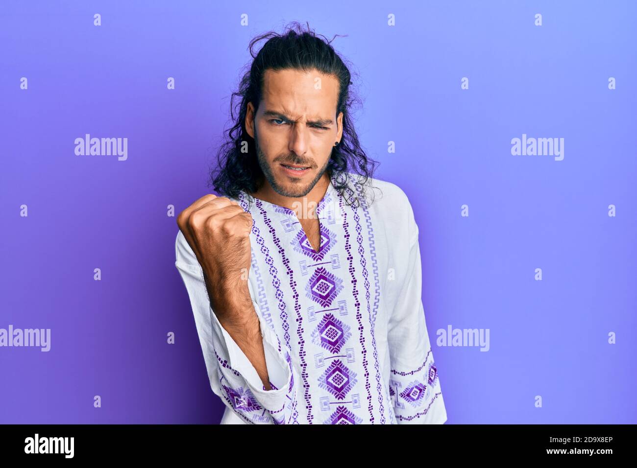 Young handsome man with long hair wearing bohemian and hippie shirt ...