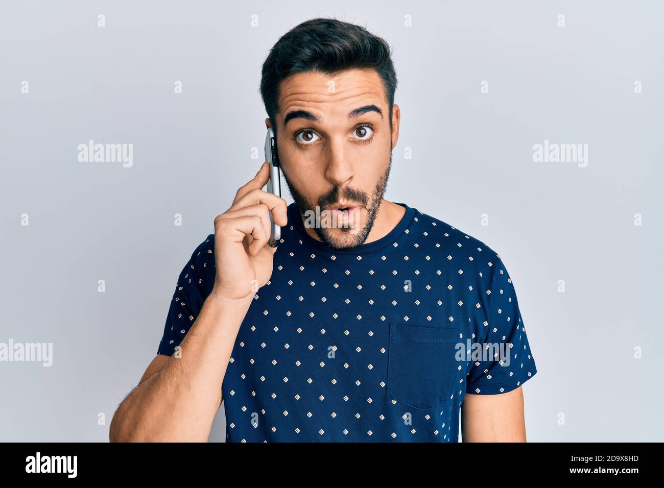 Young hispanic man having conversation talking on the smartphone scared ...