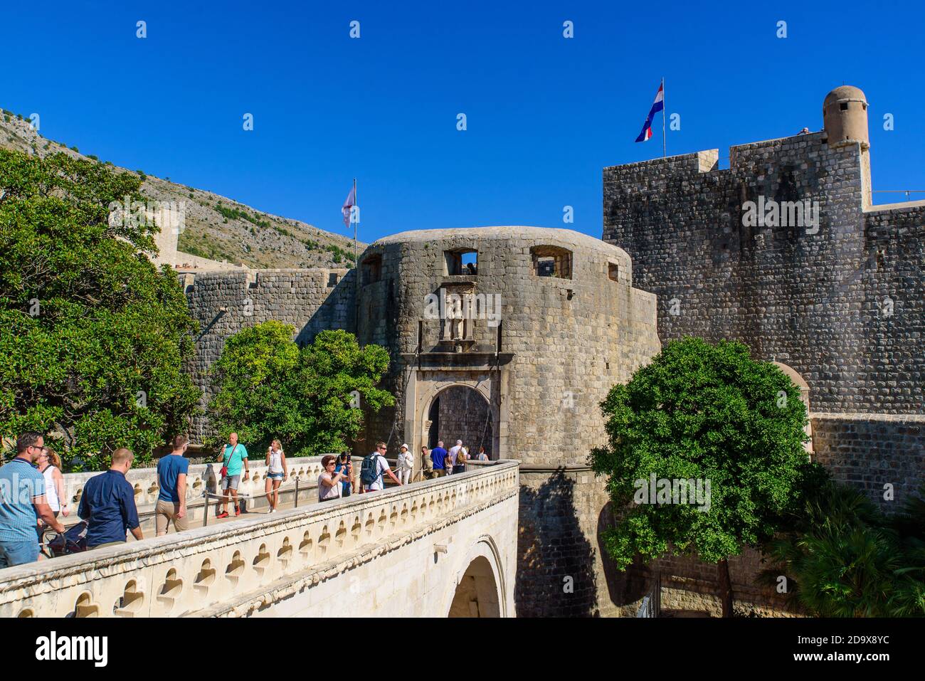 People walking through Pile Gate, the main entrance to the old town of ...