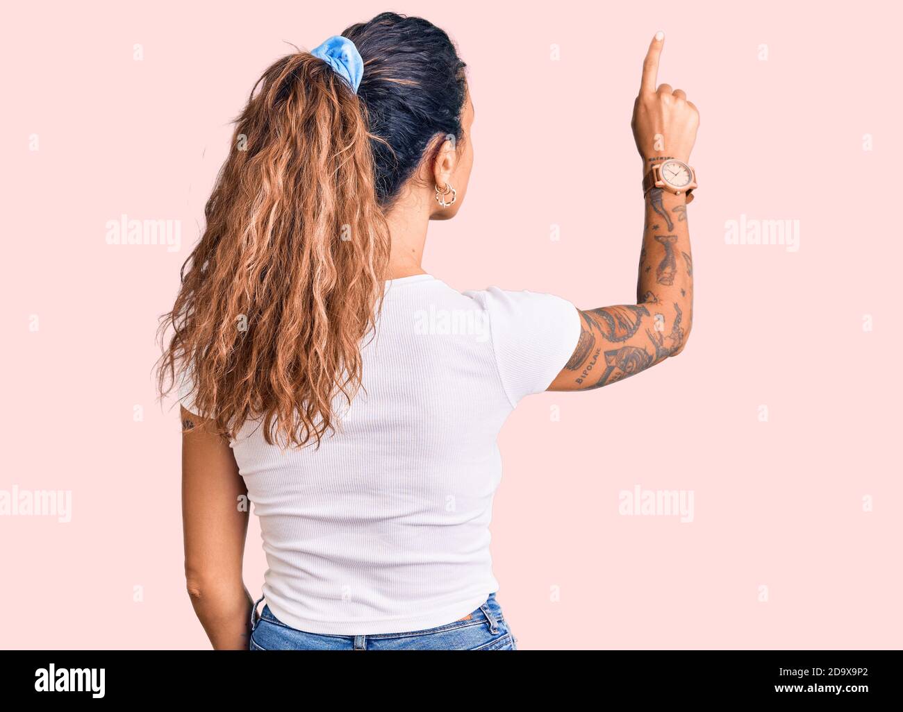 Young hispanic woman with tattoo wearing casual white tshirt posing ...