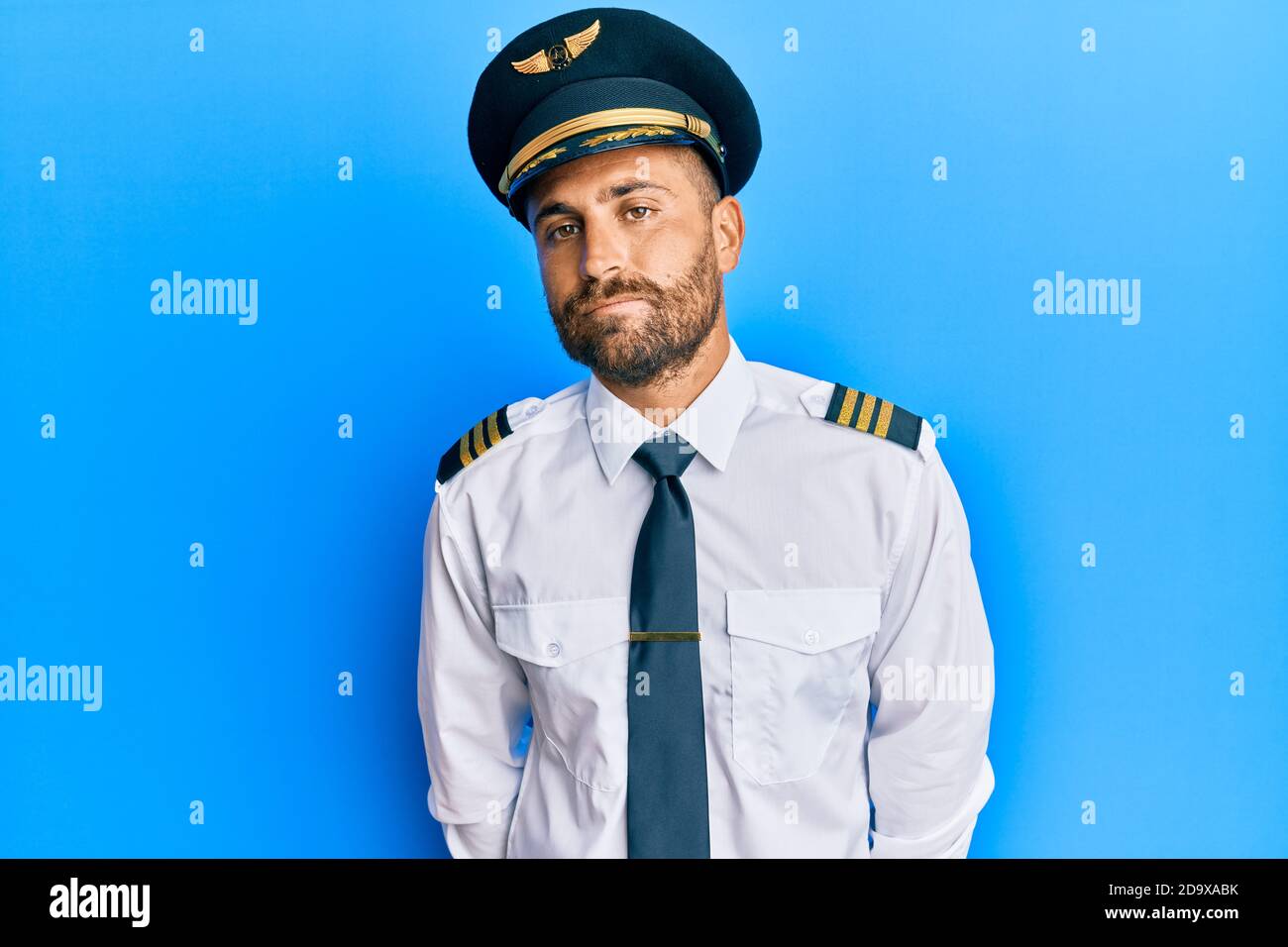 Handsome man with beard wearing airplane pilot uniform depressed and ...