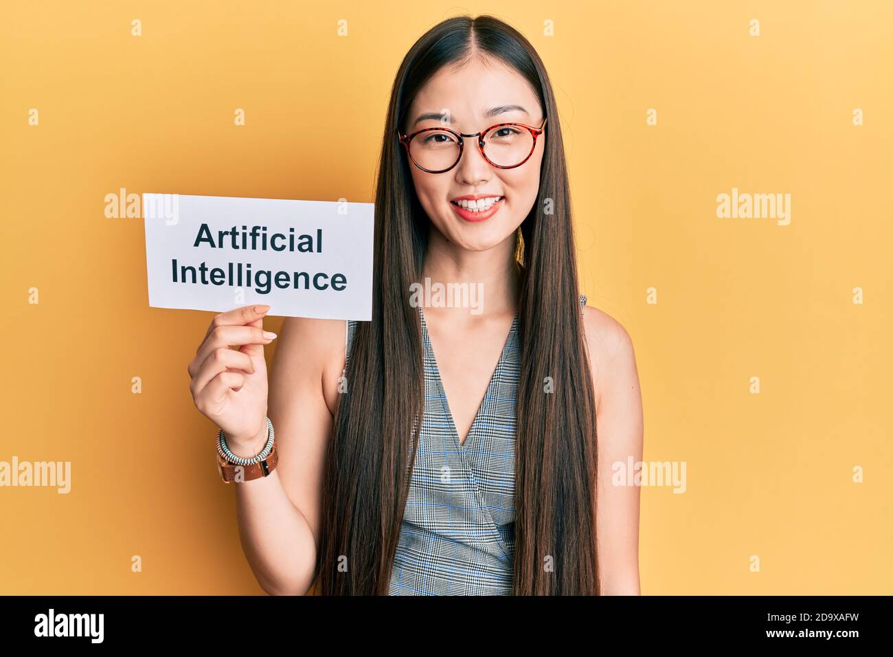 Young chinese woman holding artificial intelligence paper looking ...