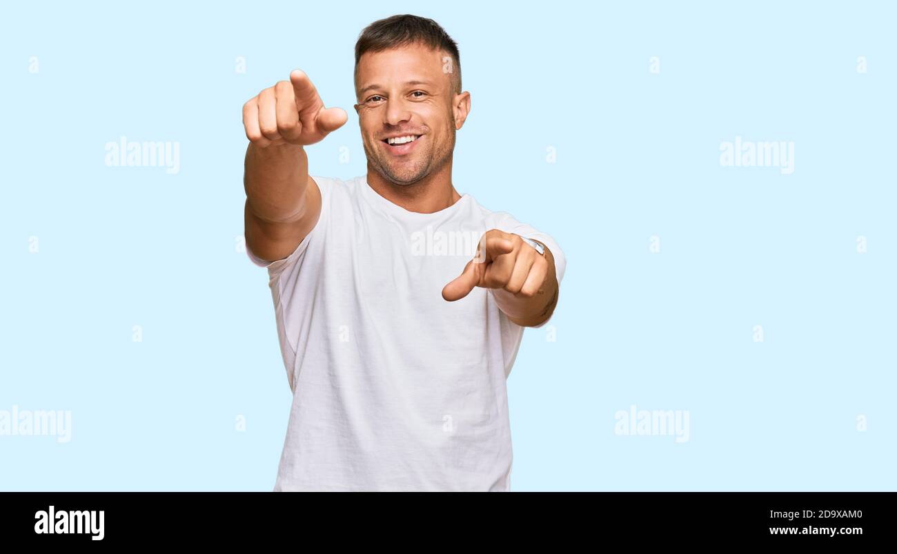 Handsome muscle man wearing casual white tshirt pointing to you and the ...