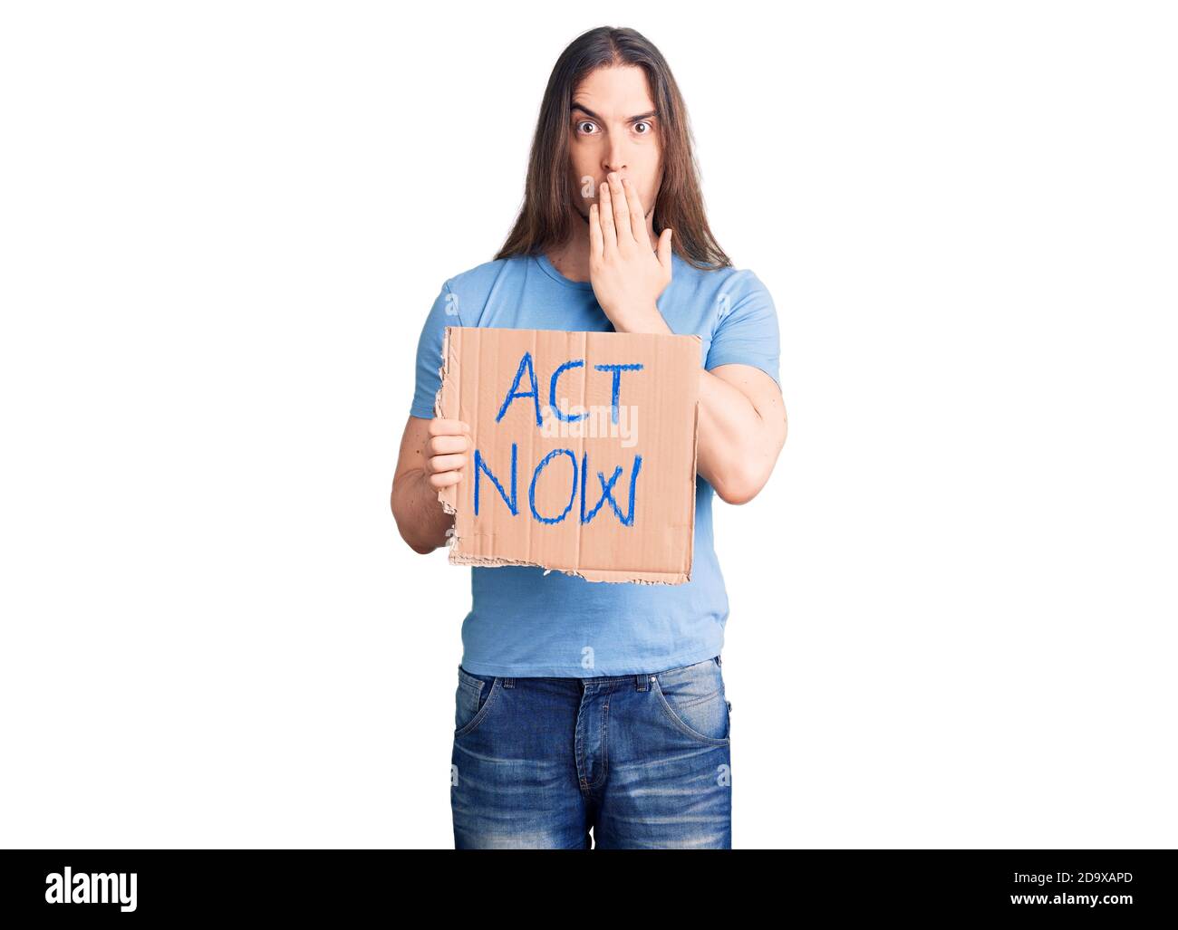 Young adult man with long hair holding act now banner covering mouth ...
