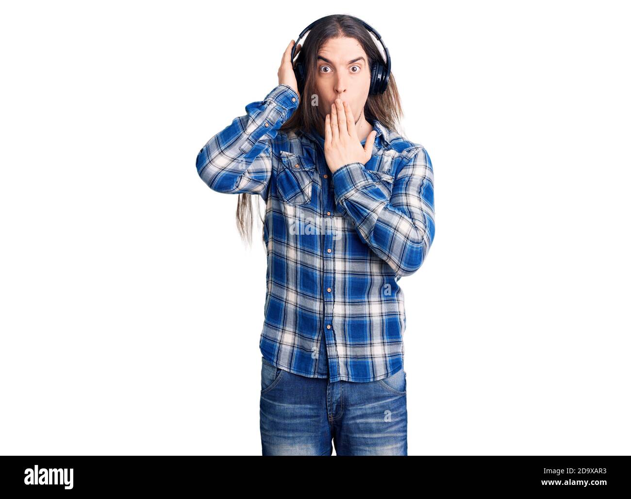 Young adult man with long hair listening to music using headphones ...