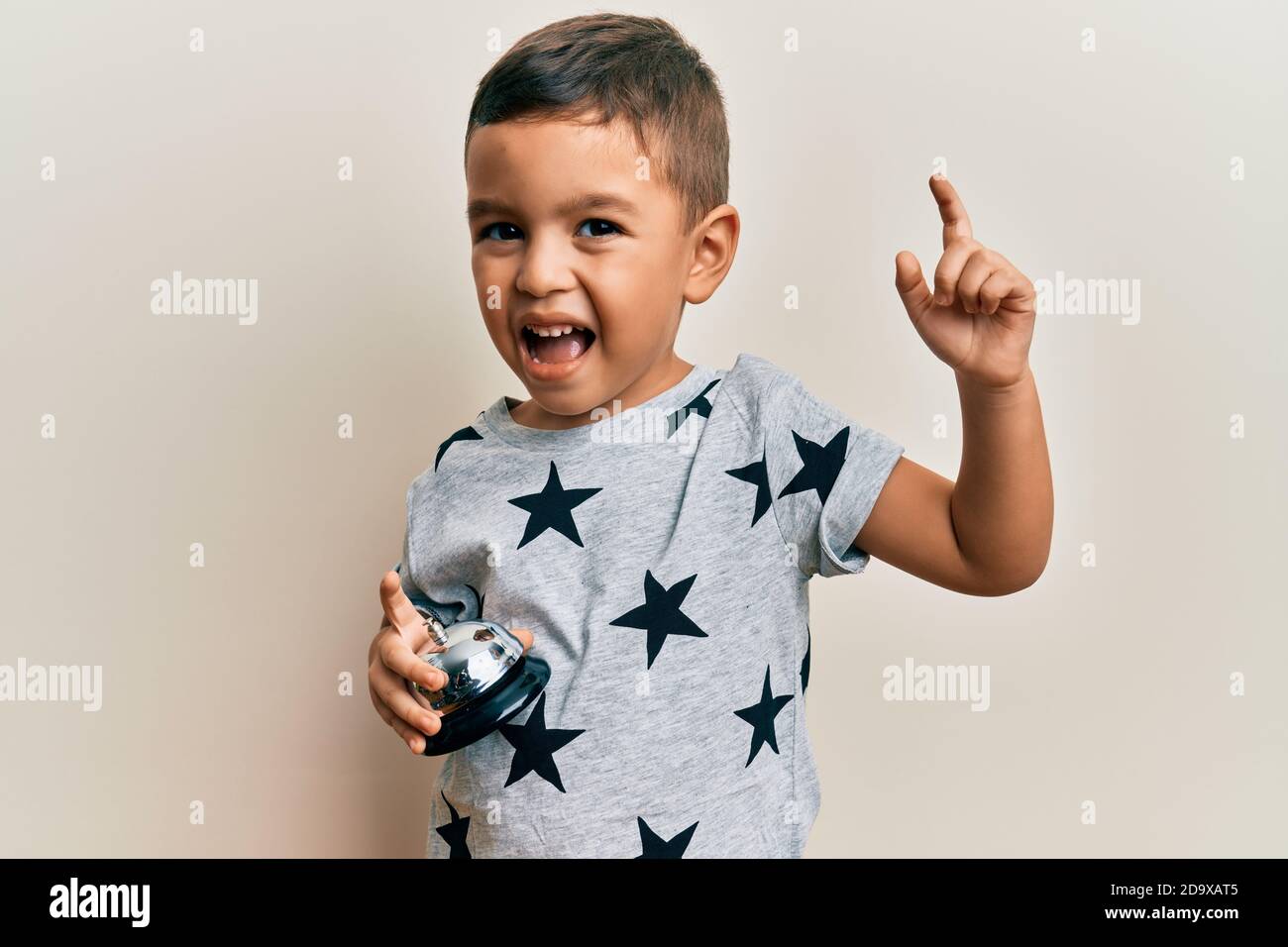 Adorable latin toddler smiling happy using receptionist ring bell over ...