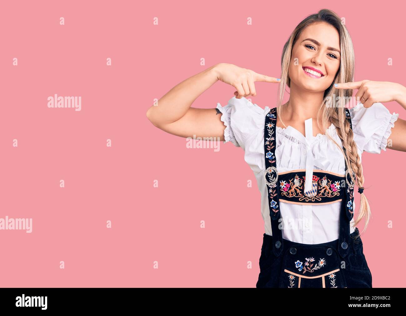 Young beautiful blonde woman wearing oktoberfest dress smiling cheerful ...