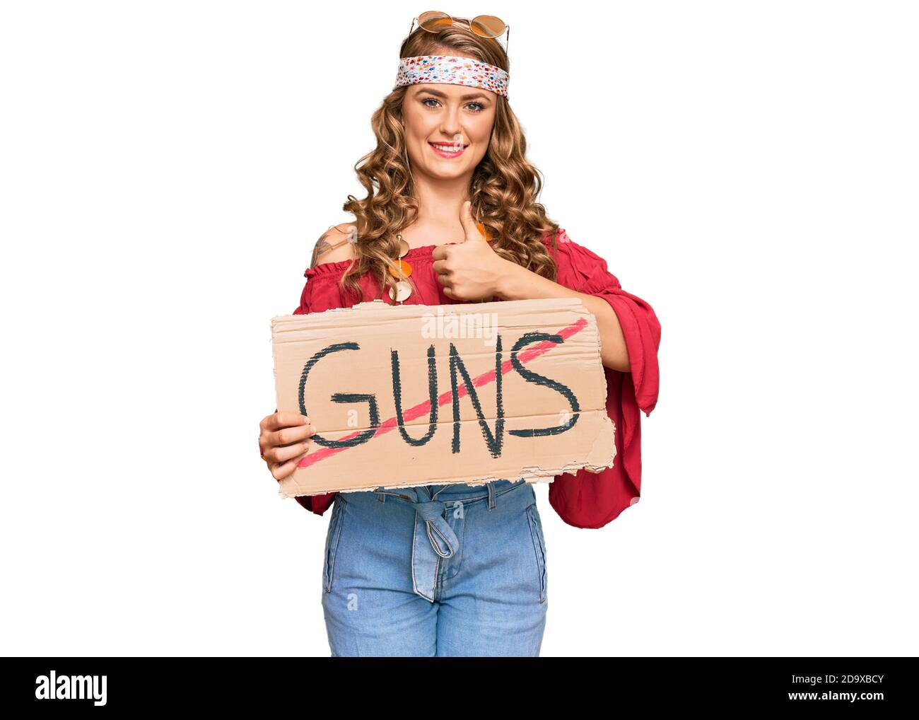 Young blonde girl wearing hippie style holding no guns warning banner ...