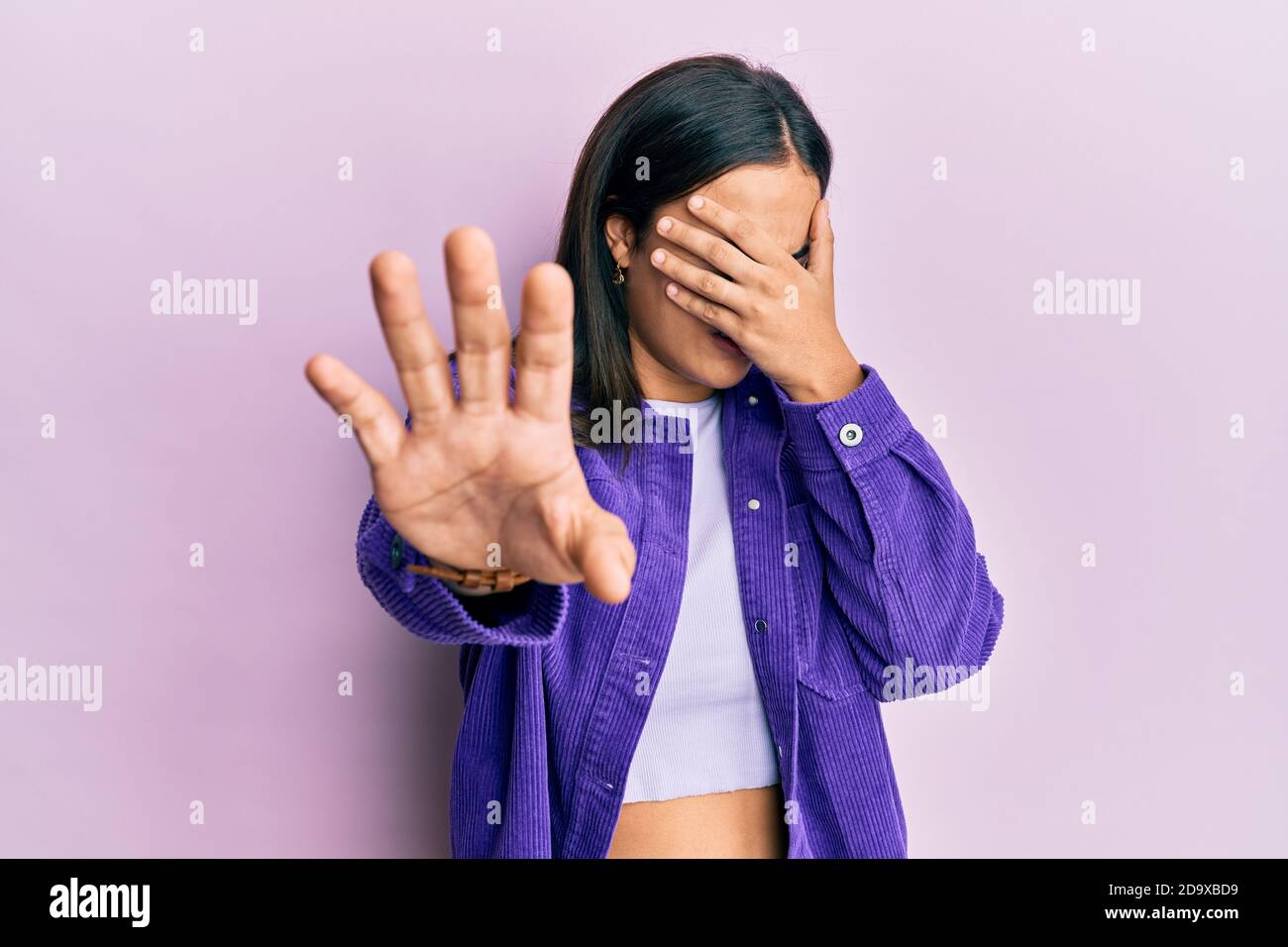 Young brunette woman wearing casual clothes covering eyes with hands ...