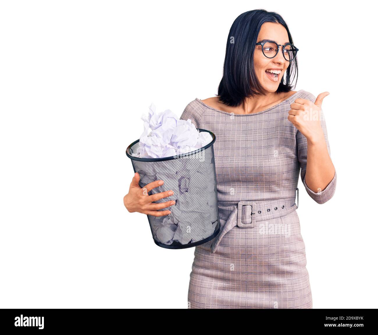 Young beautiful latin woman holding paper bin full of crumpled papers ...