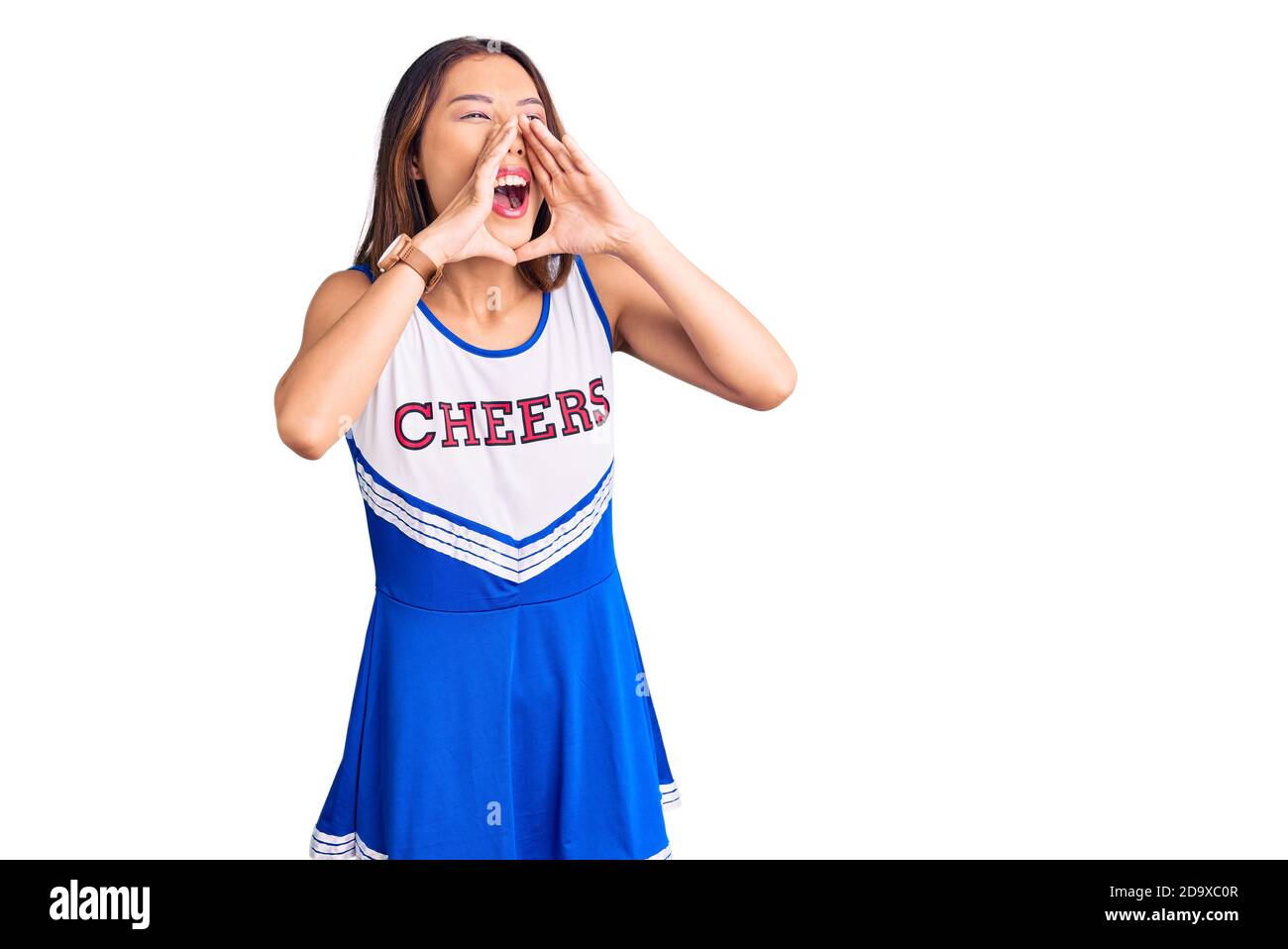 Young beautiful chinese girl wearing cheerleader uniform shouting angry ...