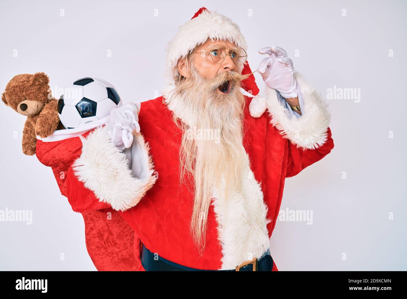 Old senior man with grey hair and long beard wearing santa claus ...