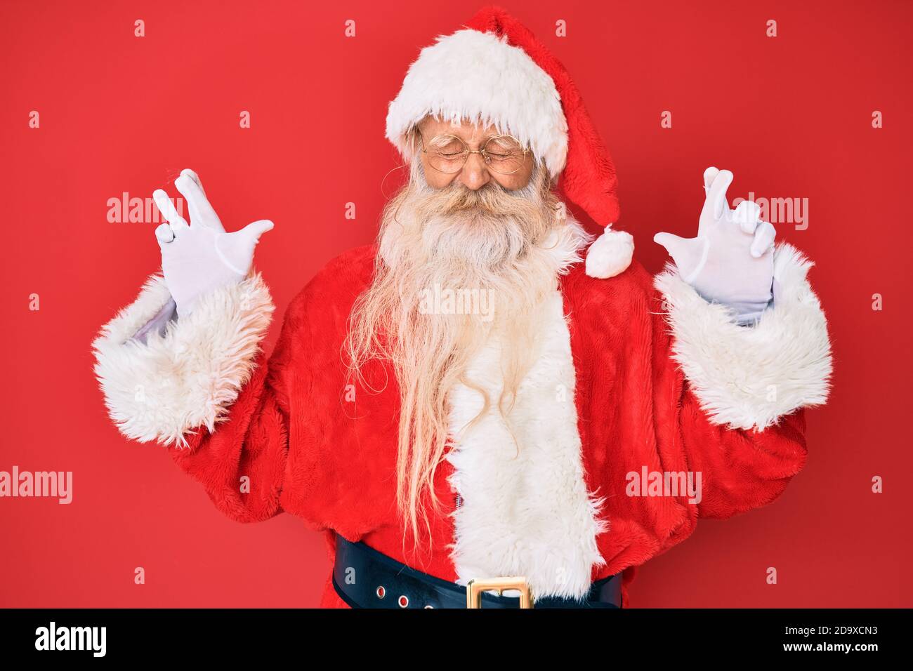 Old senior man with grey hair and long beard wearing traditional santa ...