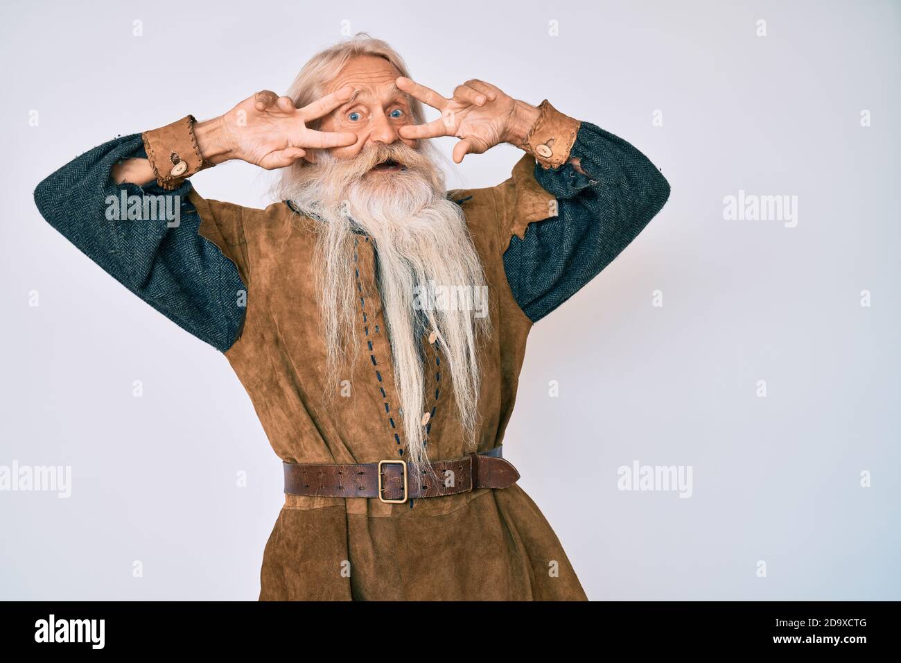 Old senior man with grey hair and long beard wearing viking traditional ...