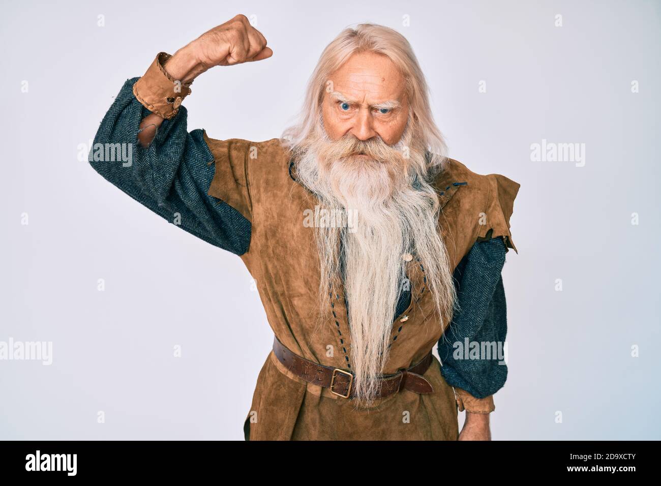 Old senior man with grey hair and long beard wearing viking traditional ...