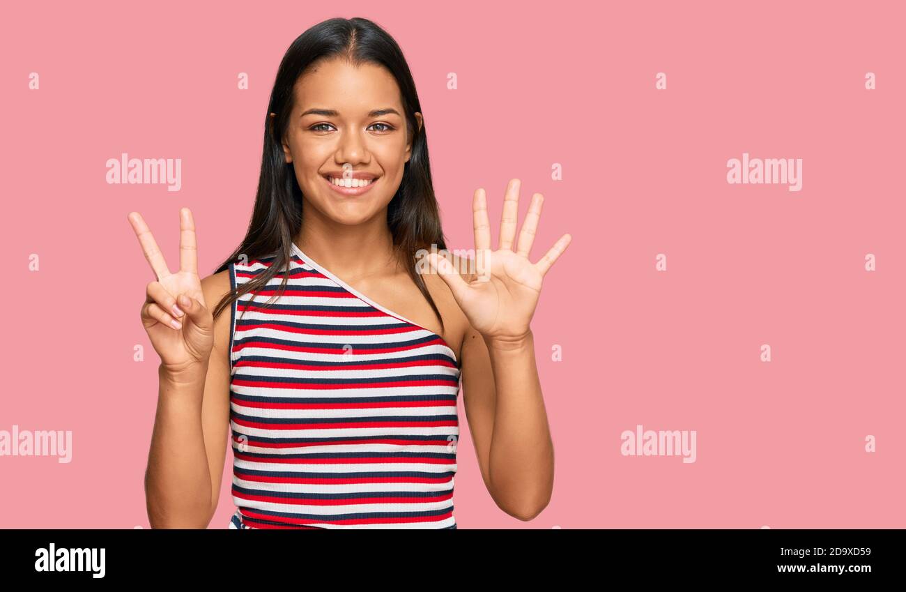 Beautiful hispanic woman wearing casual clothes showing and pointing up ...