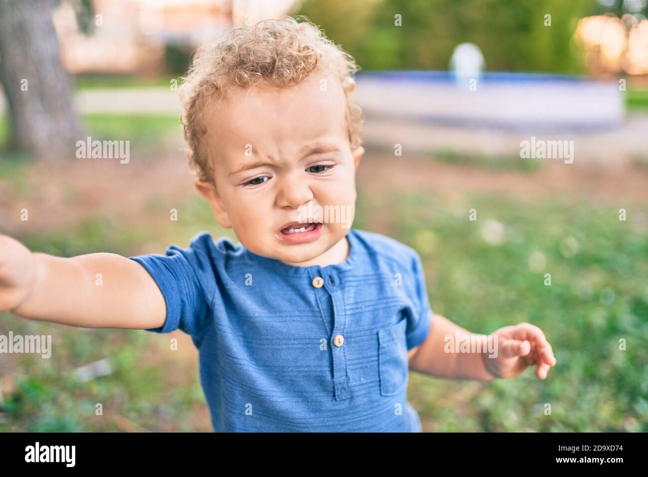 Cute and sad little boy crying having a tantrum at the park on a sunny ...