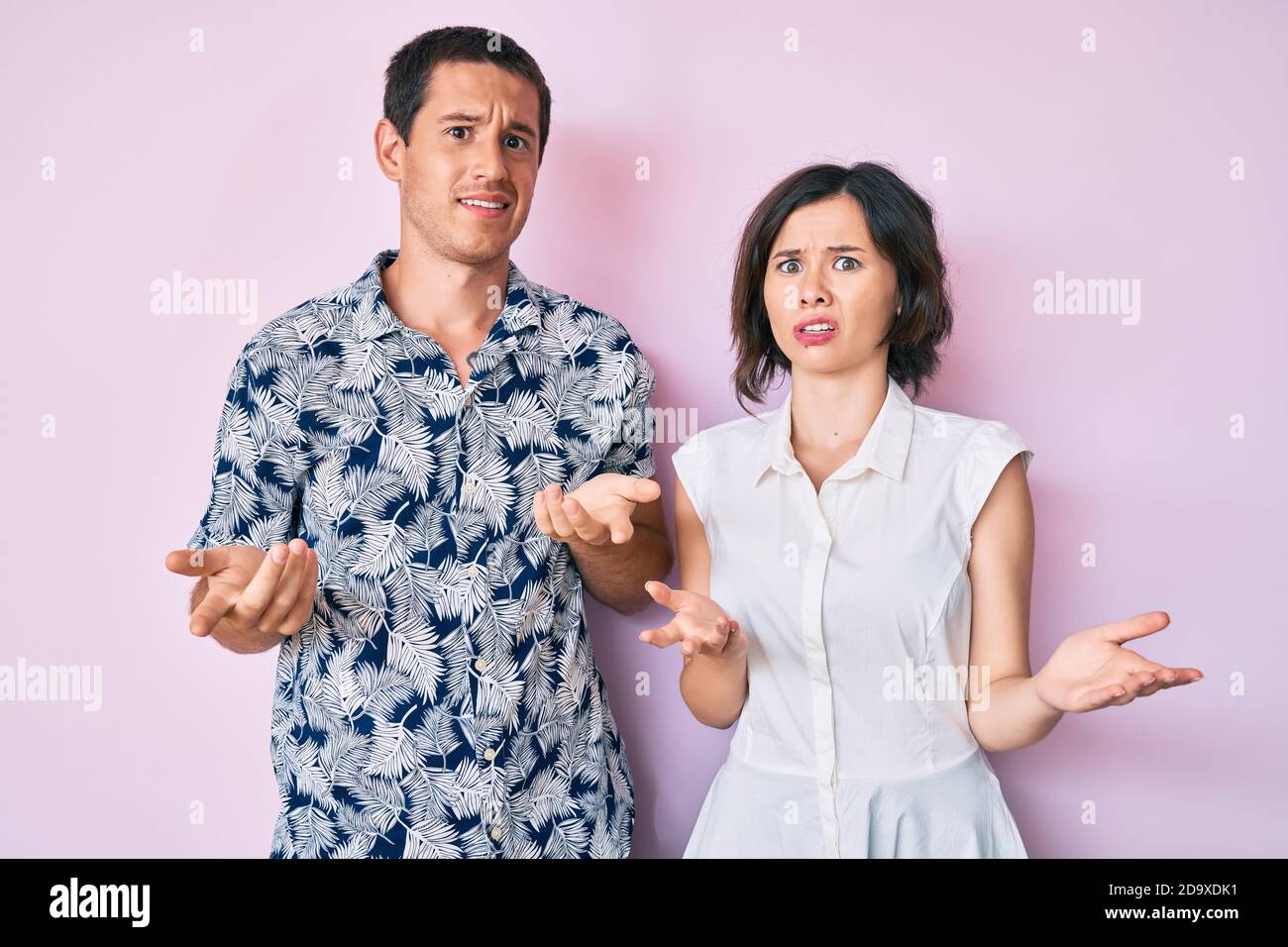 Beautiful couple wearing casual clothes clueless and confused with open ...