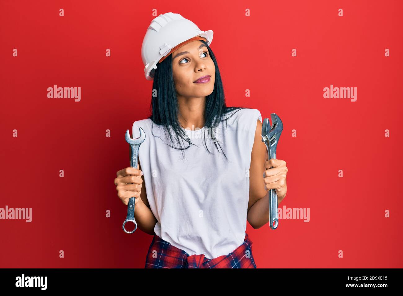 Young african american woman wearing hardhat holding wrench smiling ...