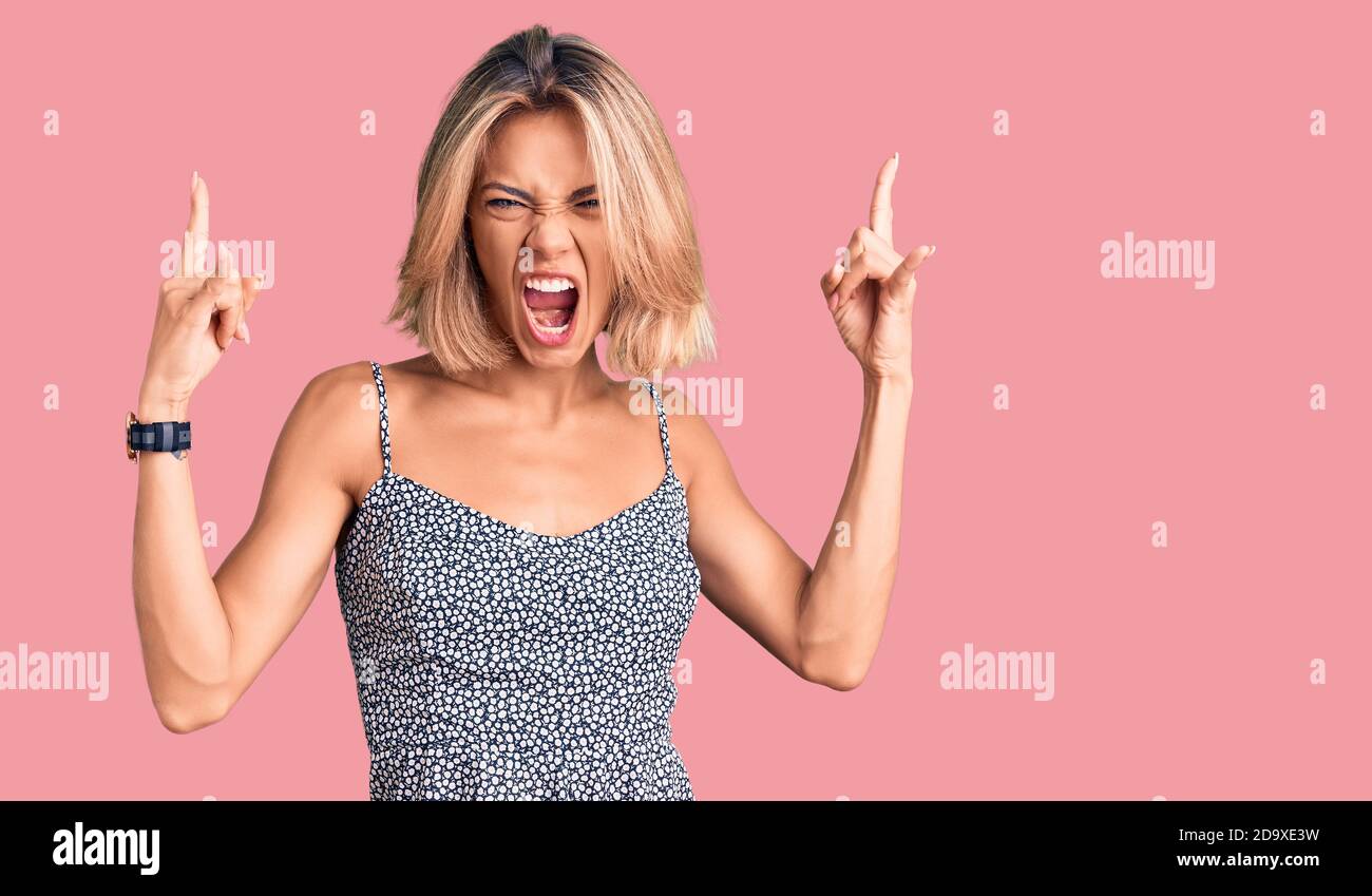 Beautiful caucasian woman wearing summer dress shouting with crazy ...