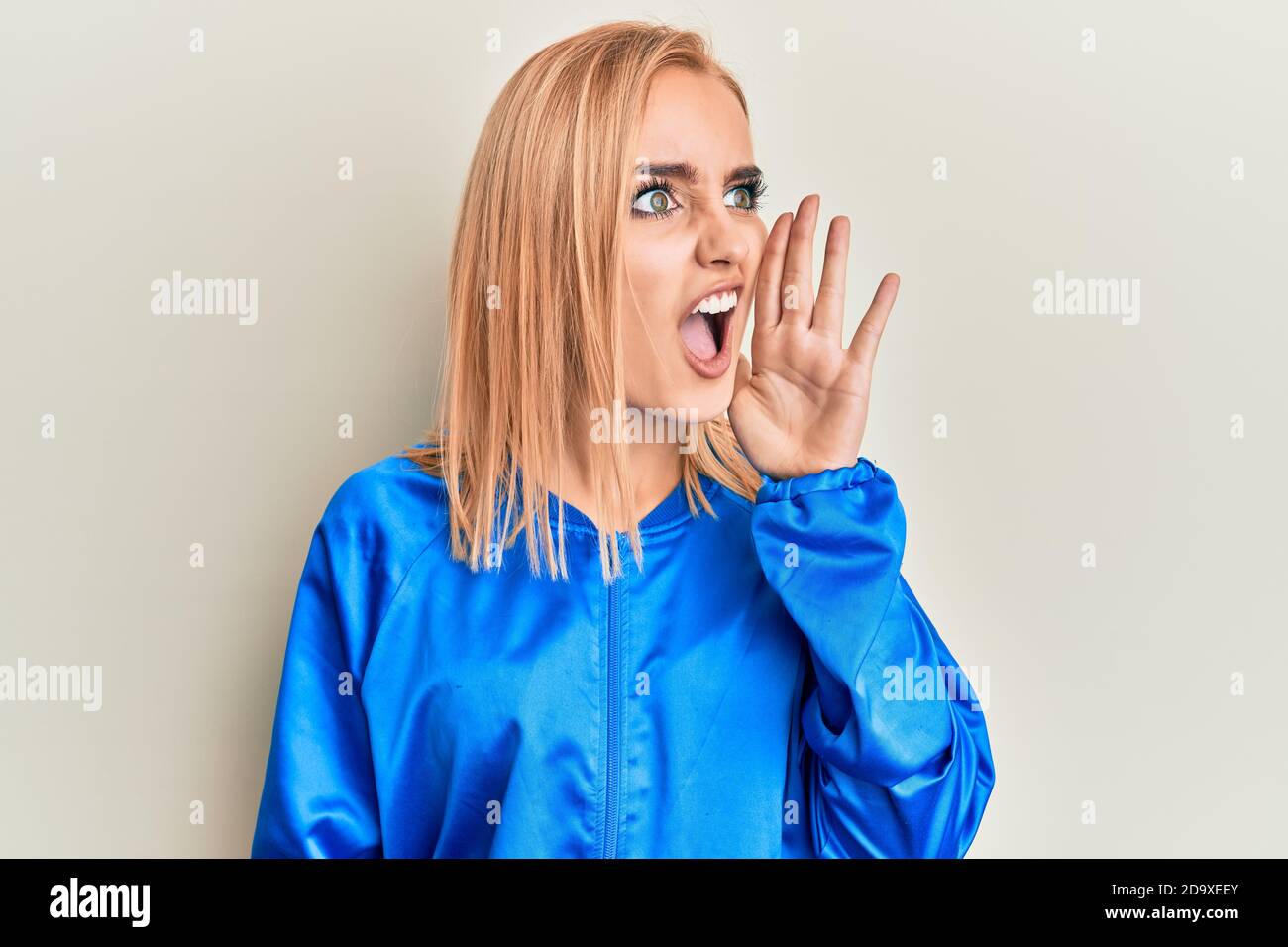 Beautiful caucasian woman wearing sportswear shouting and screaming ...