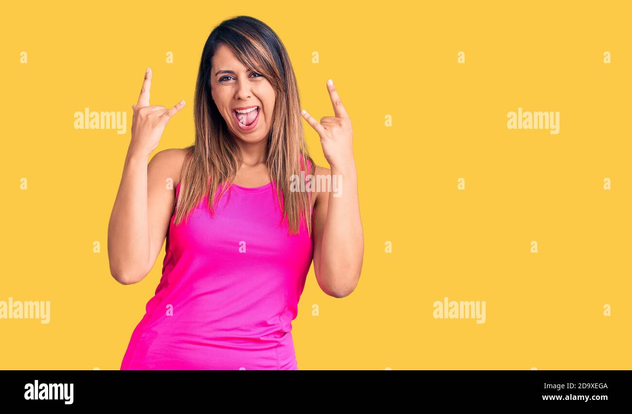 Young beautiful woman wearing sportswear shouting with crazy expression ...
