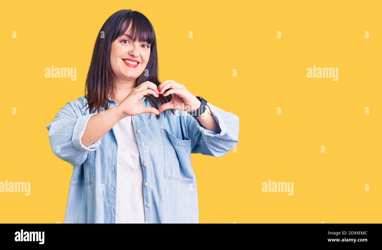Young plus size woman wearing casual clothes smiling in love showing ...
