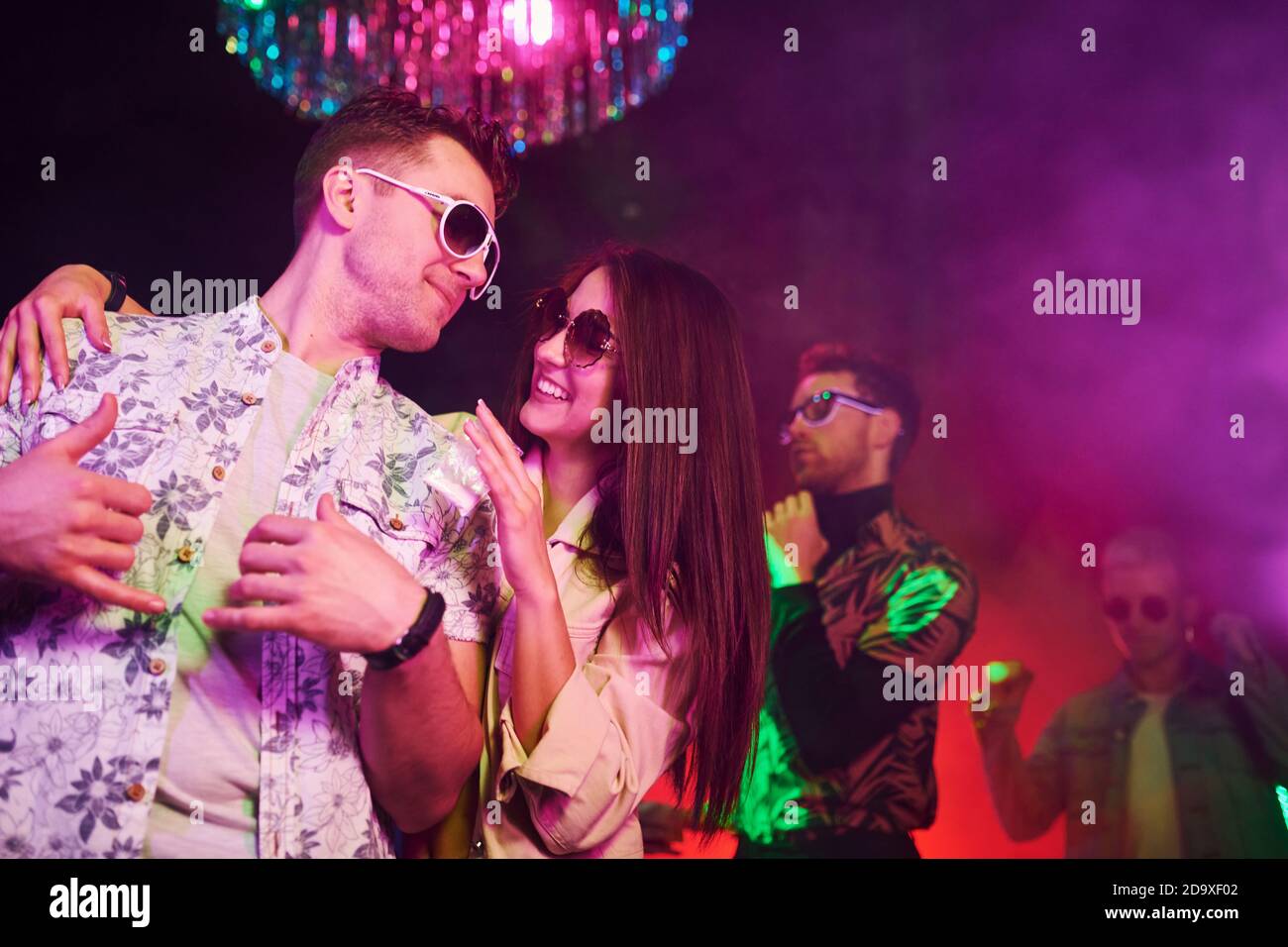 Buying drugs. Young people is having fun in night club with colorful ...