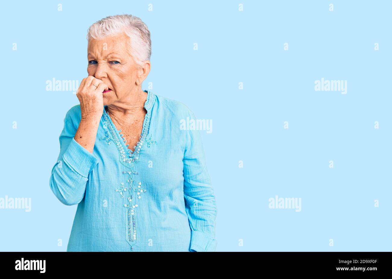 Senior beautiful woman with blue eyes and grey hair wearing summer ...