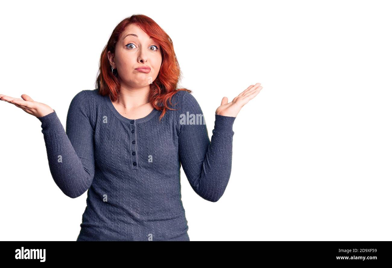 Young beautiful redhead woman wearing casual t-shirt clueless and ...