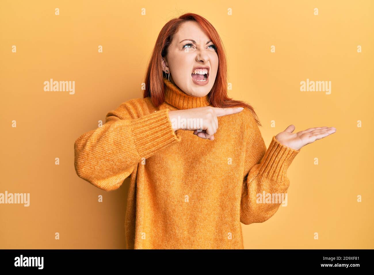 Beautiful redhead woman pointing with finger to empty space on open ...