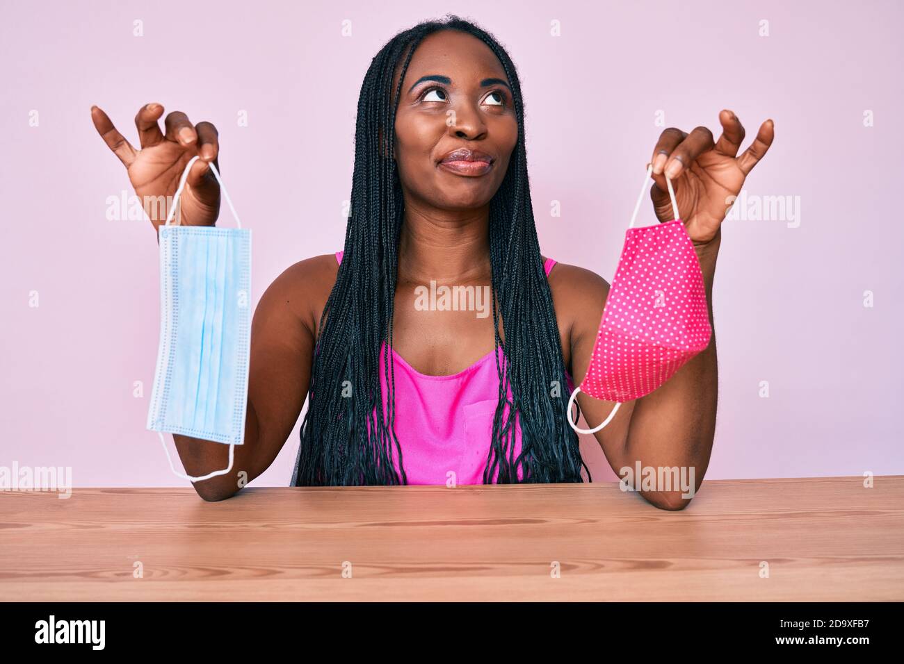 African american woman with braids holding two different safety masks ...