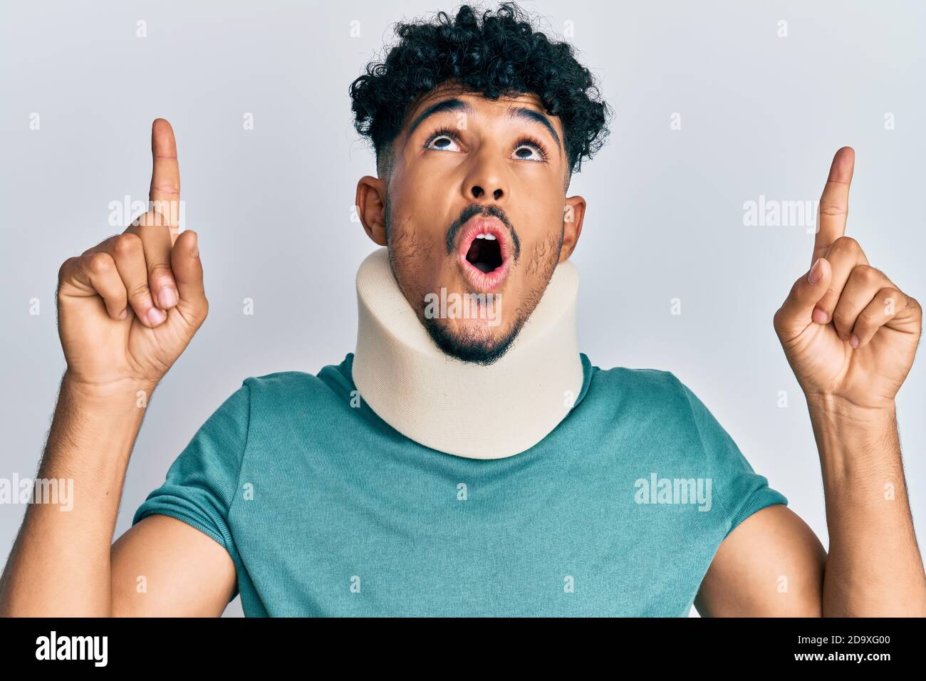 Young arab handsome man wearing cervical neck collar amazed and ...