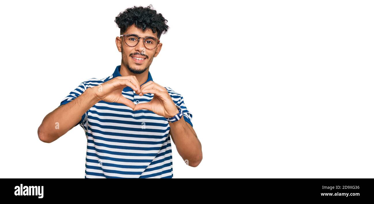 Young arab man wearing casual clothes and glasses smiling in love doing ...